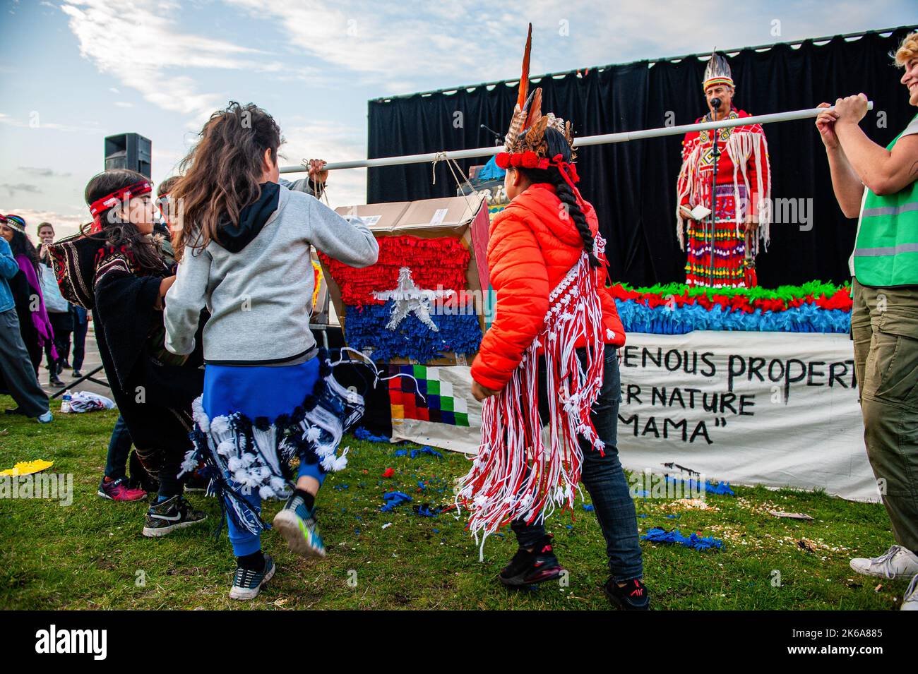 A group of Indigenous children seen destroying a piñata in the shape of ...