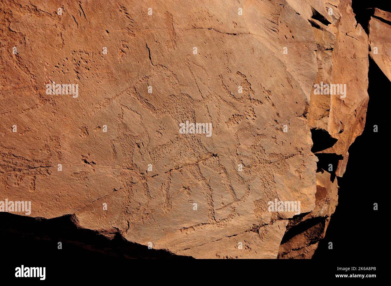 A large flat red stone with ancient drawings on the surface. Figure ...