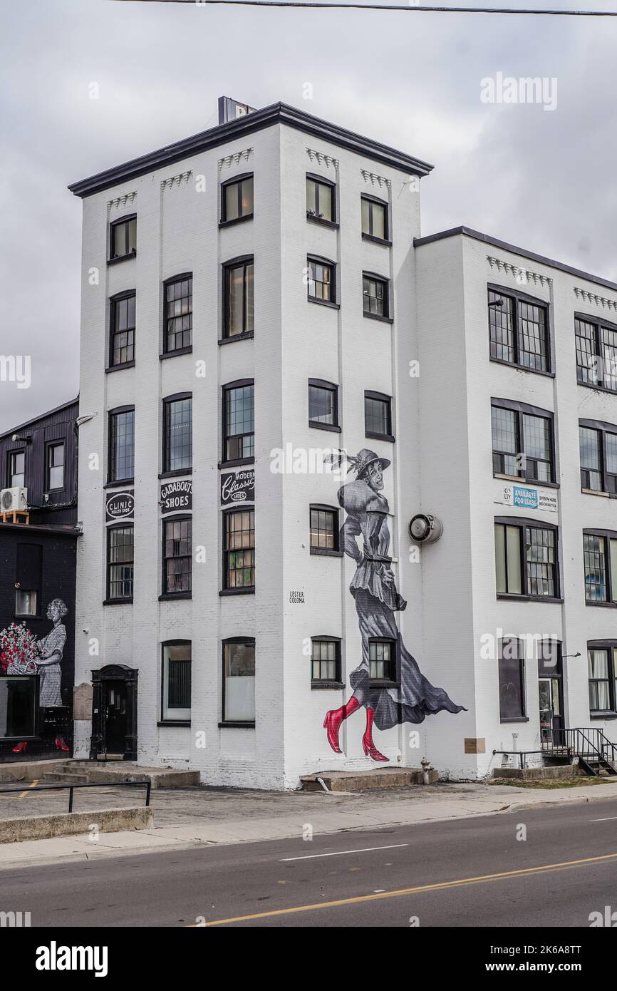 An old factory style building with mural outside of its white wall for ...