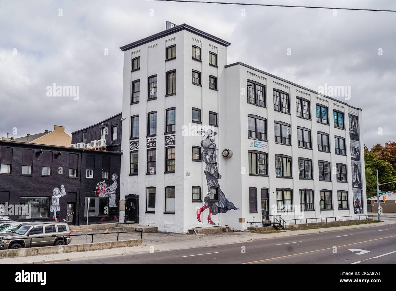 An old factory style building with mural outside of its white wall for ...