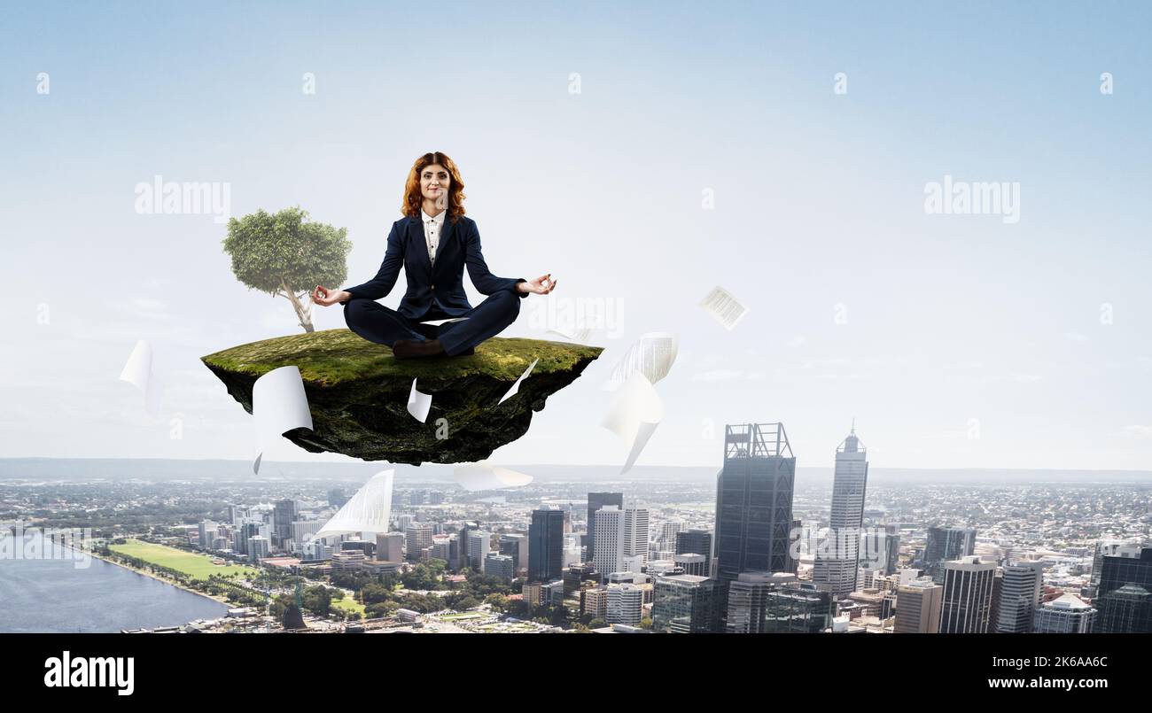 Beautiful businesswoman meditating . Mixed media Stock Photo - Alamy