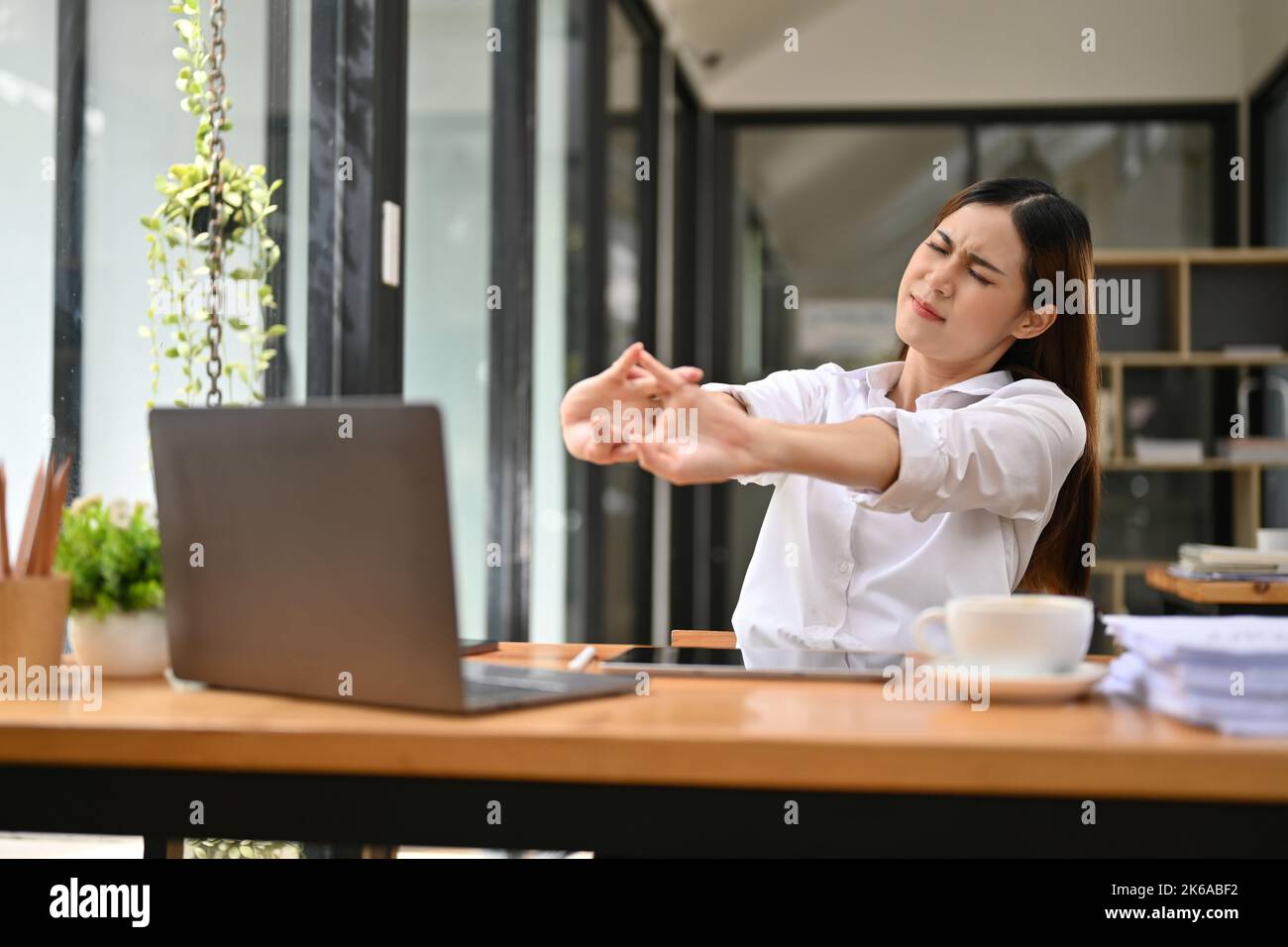 Tired and uncomfortable young Asian businesswoman or female office ...