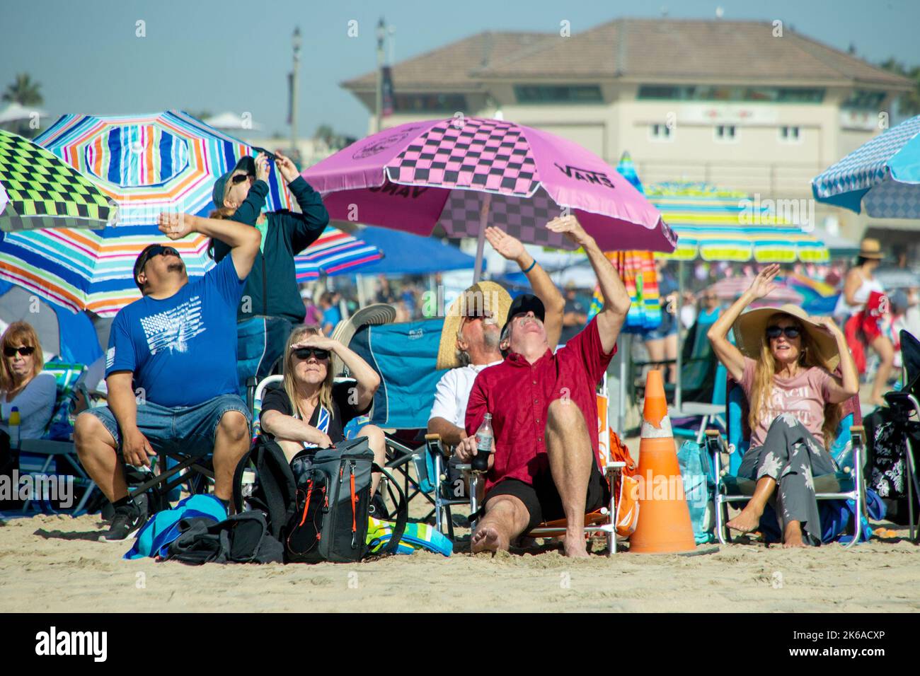 Beachgoers shade their eyes and look skyward at a July 4th air show in ...
