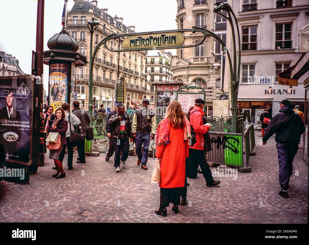 Multiracial passersby stroll past a subway entrance in Paris, France ...