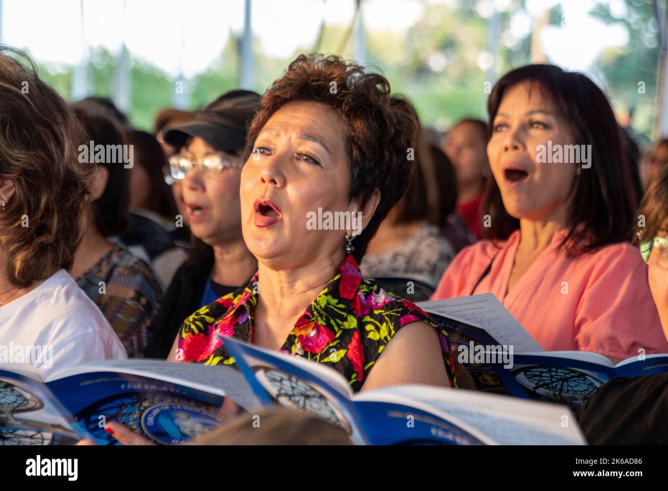 Multiracial female choir members rehearse for a religious ceremony at a ...