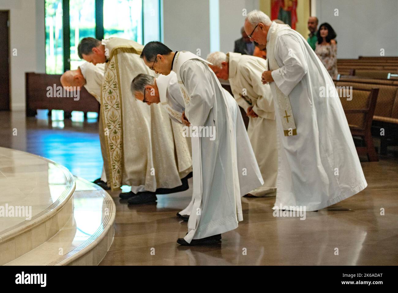 Multiracial priests and deacons bow before the altar of a Southern ...