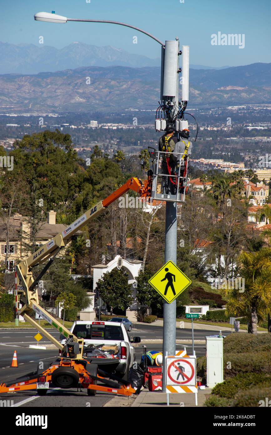 Using a portable cherry picker crane, maintenance workers repair a ...