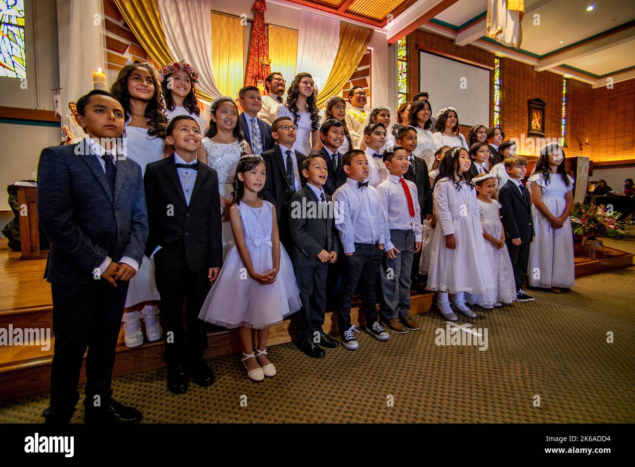 Formally dressed multiracial children pose after their first communion ...