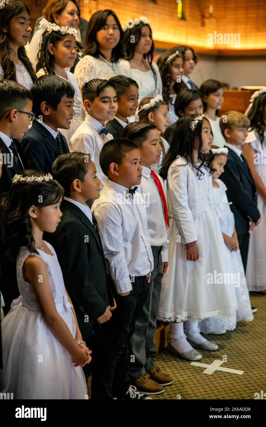 Formally dressed multiracial children pose after their first communion ...