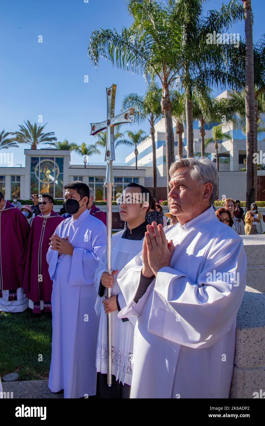 Robed multiracial participants pray in a Catholic dedication ceremony ...