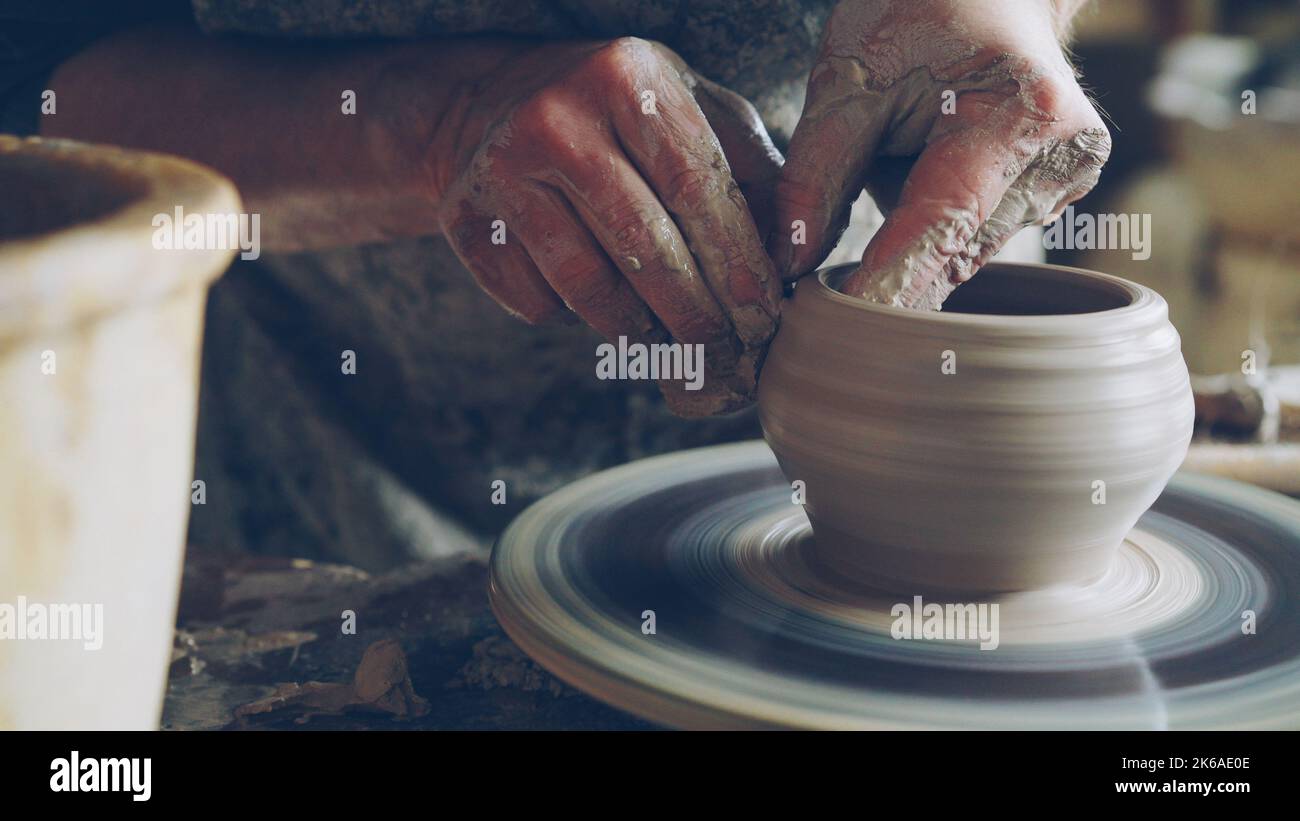 Work in pottery workshop: clay ware on throwing wheel, master ceramist ...