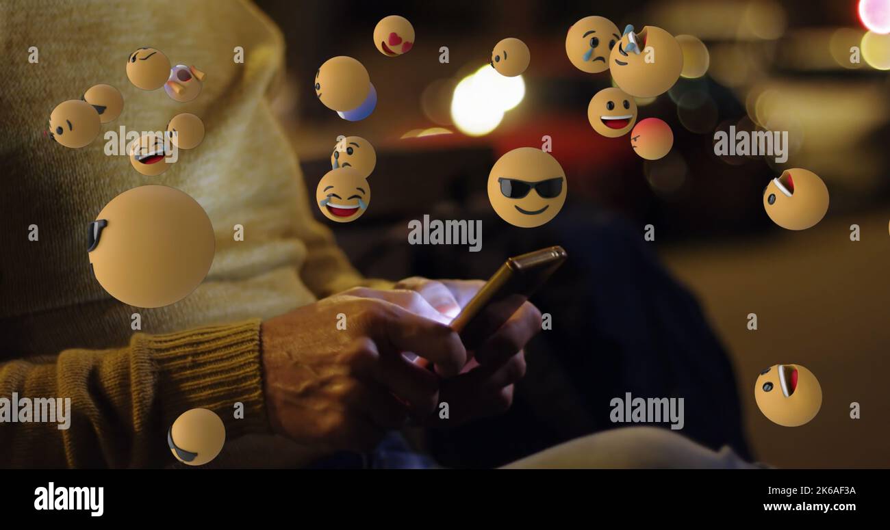 Image of emoticons over hands of senior caucasian man with smartphone ...