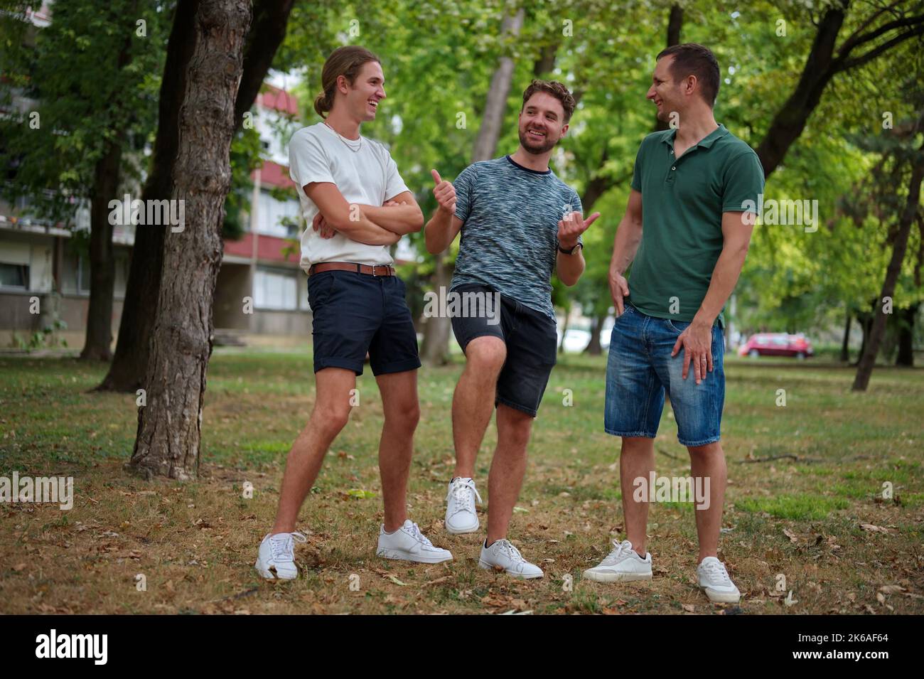 Three handsome young men having fun in a park Stock Photo - Alamy