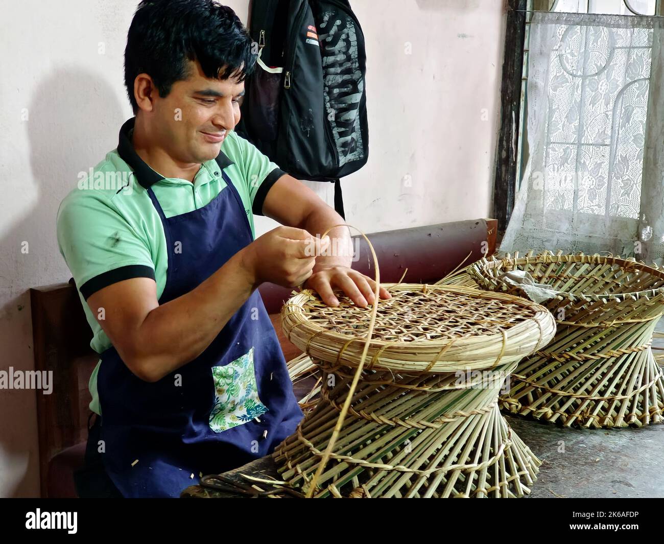 Sikkim, India - June 17 2022, An Indian craftsman weaves a cane Sitting ...