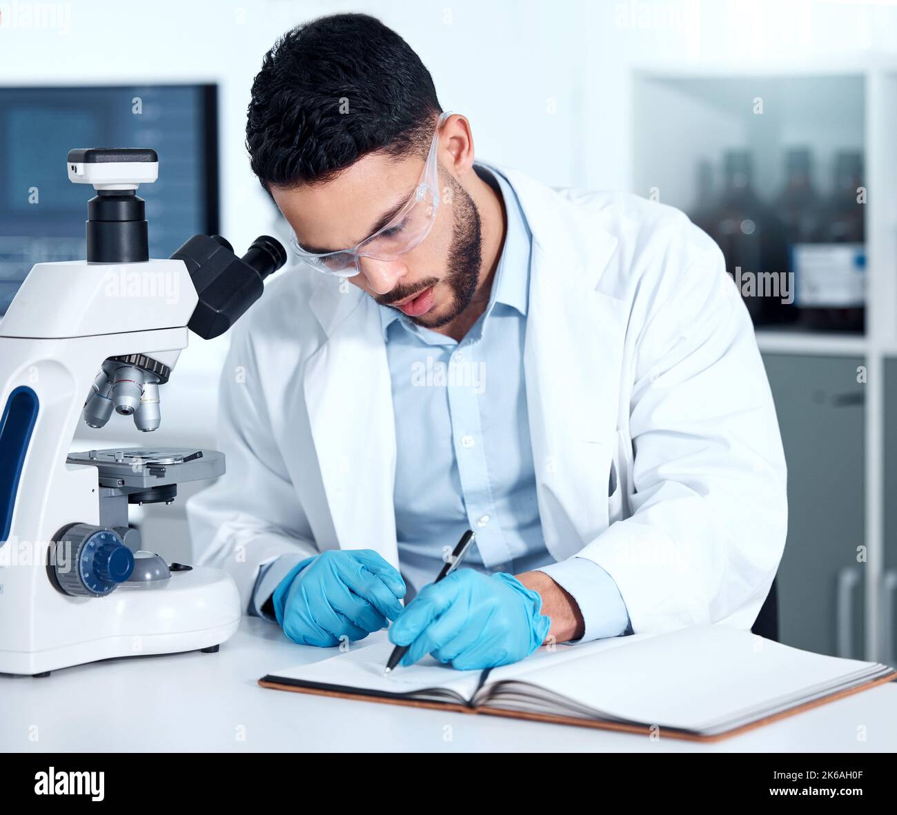 Serious young mixed race male scientist wearing glasses and gloves ...