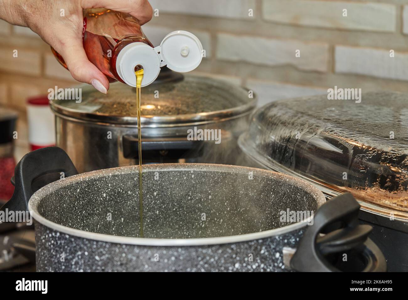 Pours maple syrup into the pot with the dish being prepared Stock Photo ...
