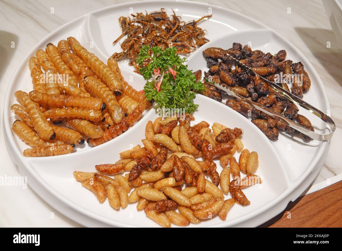 YANTAI, CHINA - OCTOBER 4, 2022 - Fried silkworm pupae are seen at a ...