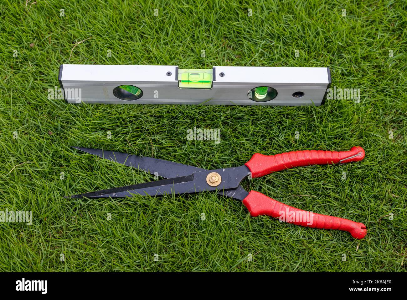 Trimmer and level tool on a the grass Stock Photo - Alamy