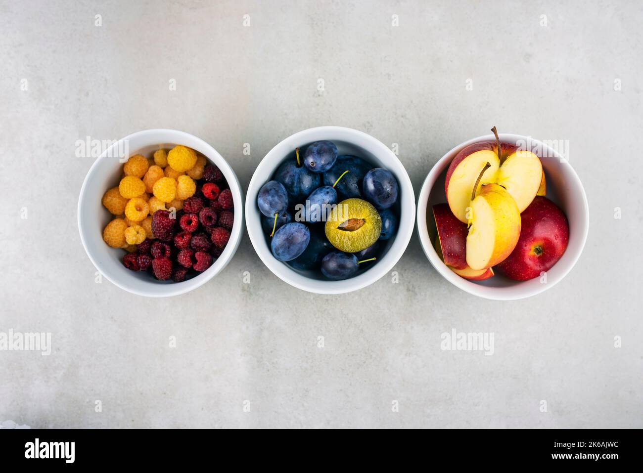 A top view of cups full of fruits in white background Stock Photo - Alamy
