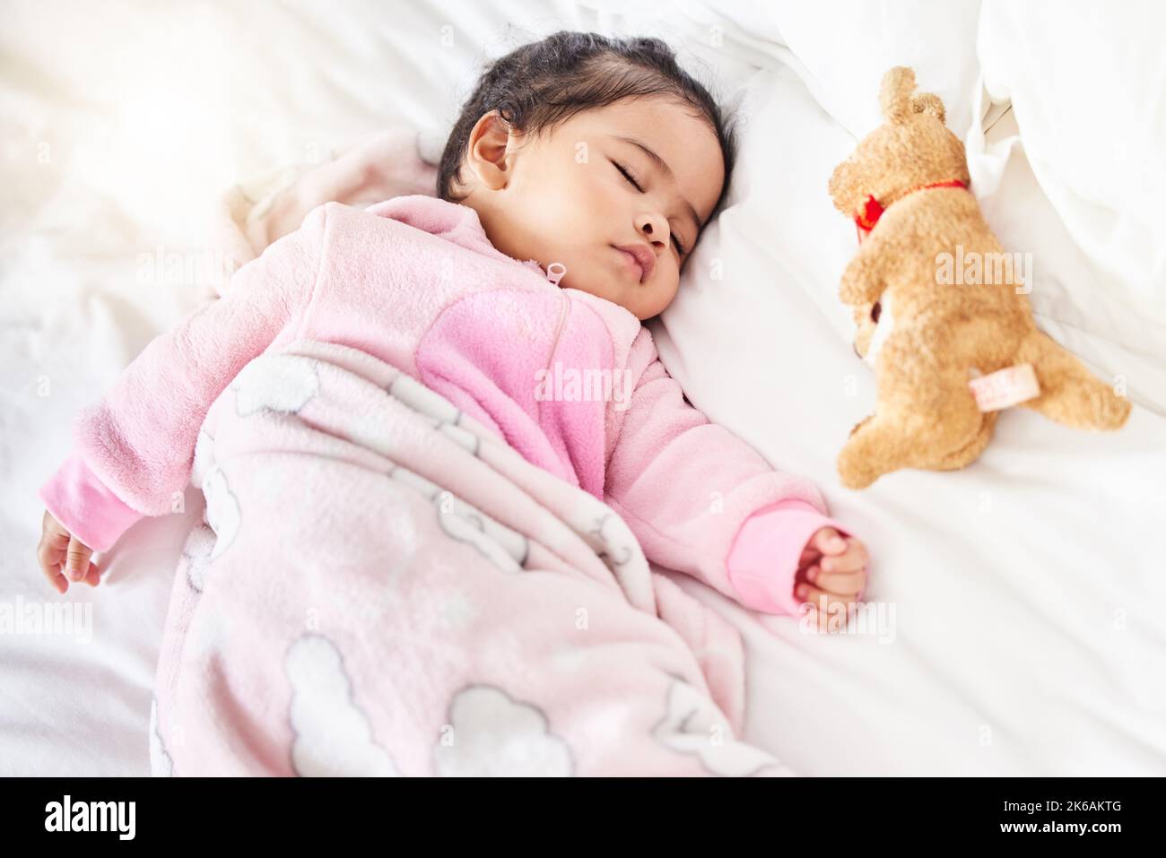 Adorable baby girl sleeping peacefully in her bed with stuffed animal ...