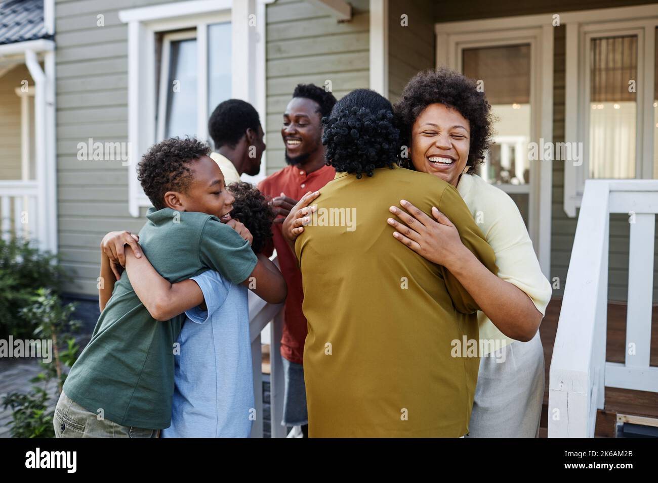 Big African American family embracing outdoors welcoming guests for ...