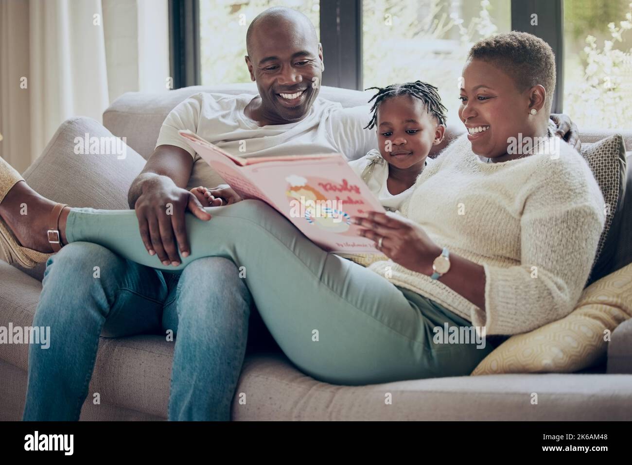 Family story time. a young family reading a book together at home Stock ...