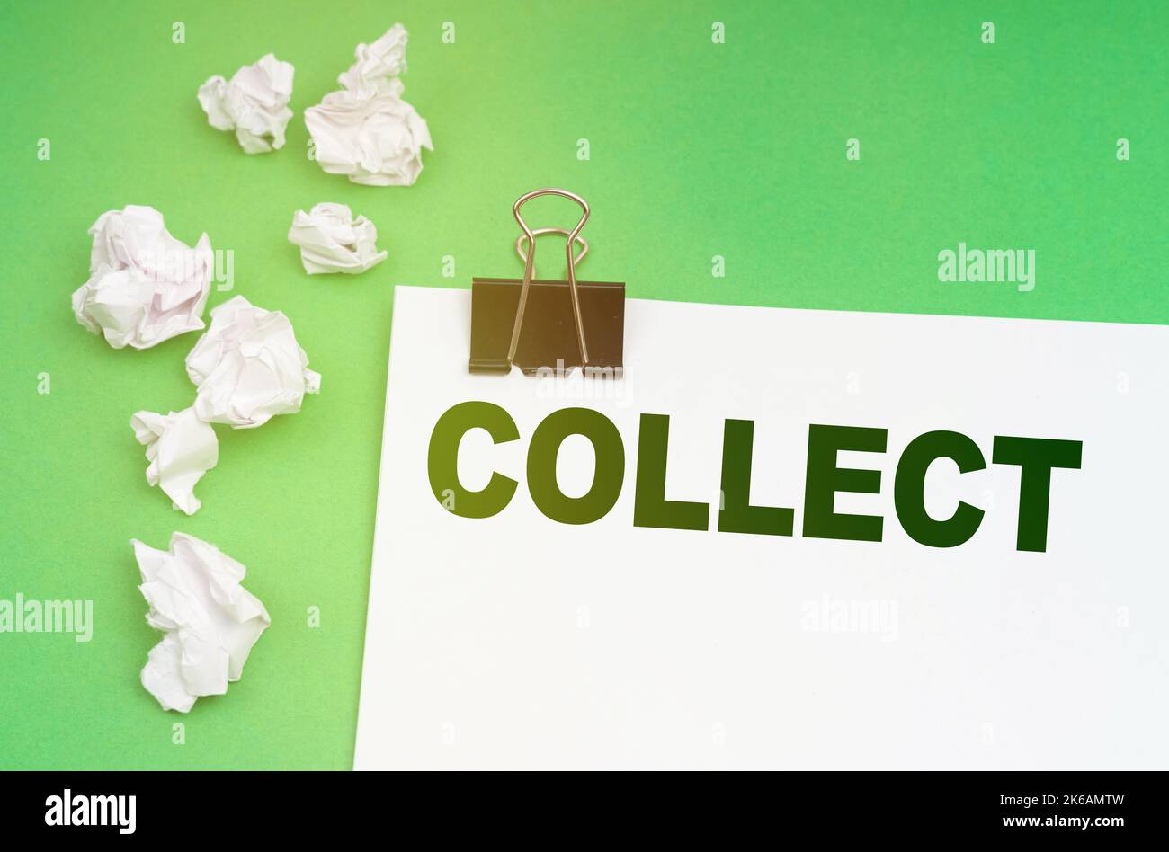 Ecology concept. On a green background, crumpled paper and a sheet with ...