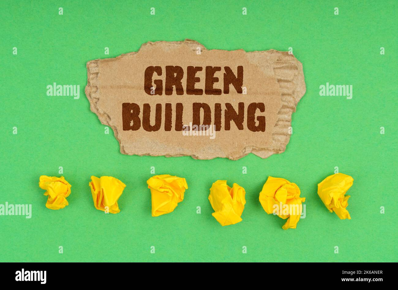 Ecology concept. On a green background, crumpled yellow paper and a ...