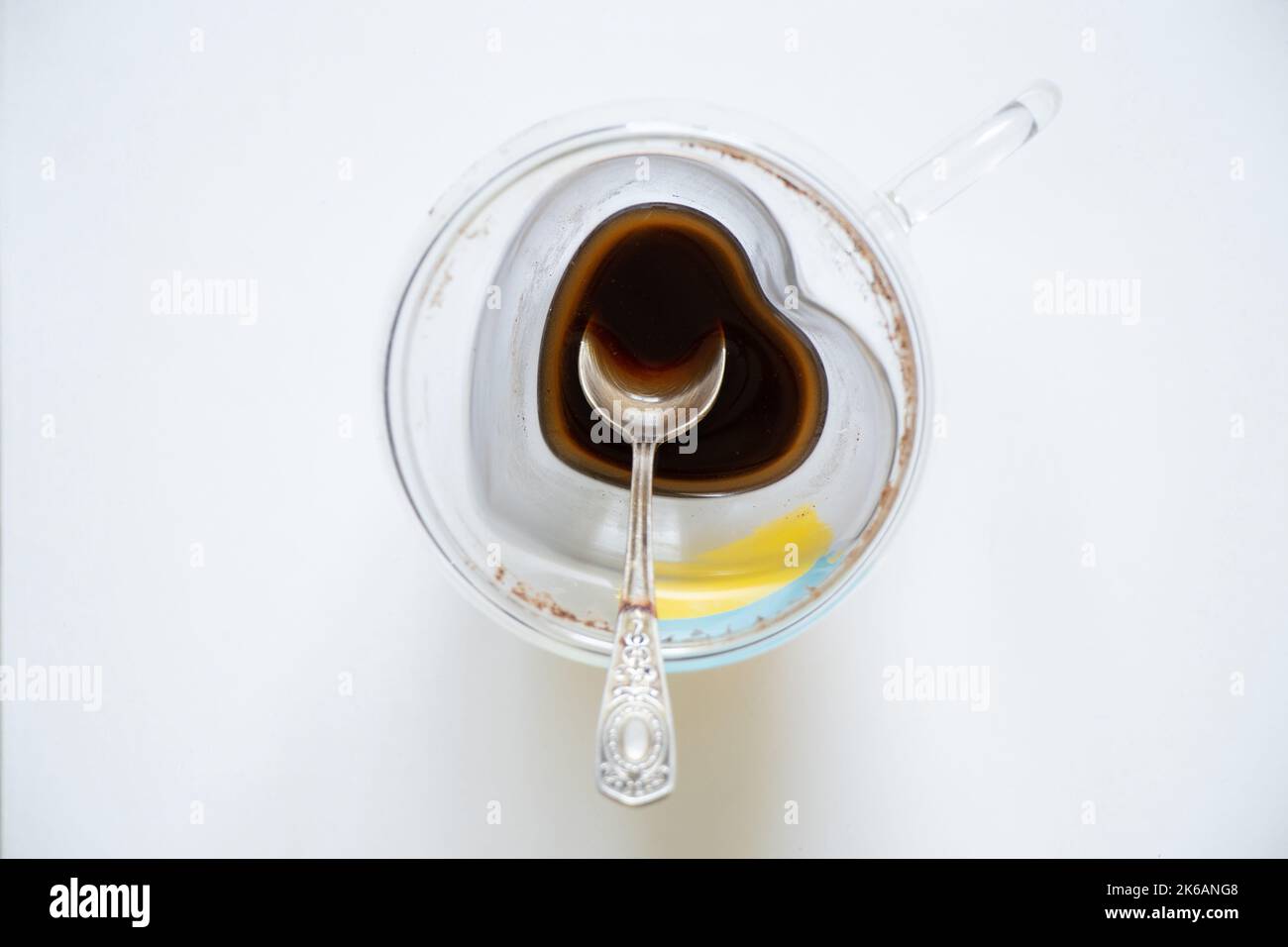 A cup of coffee with an unfinished drink on a white table top down and ...