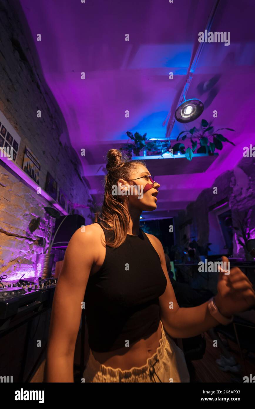Beautiful female DJ dancing to techno in a small club Stock Photo - Alamy