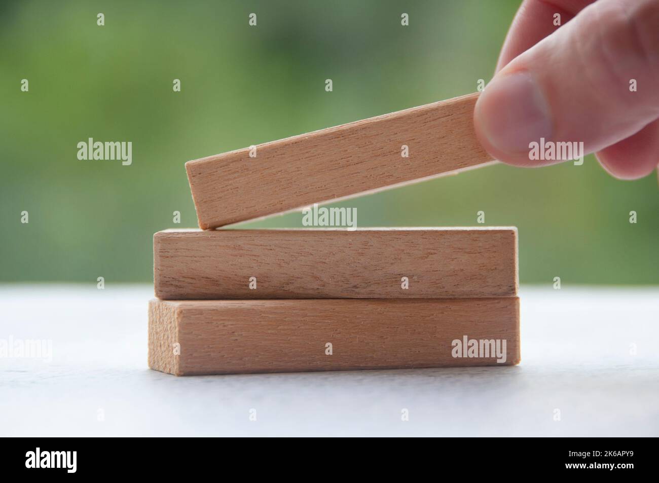 Hand lifting one wooden block with customizable space for text or ideas ...