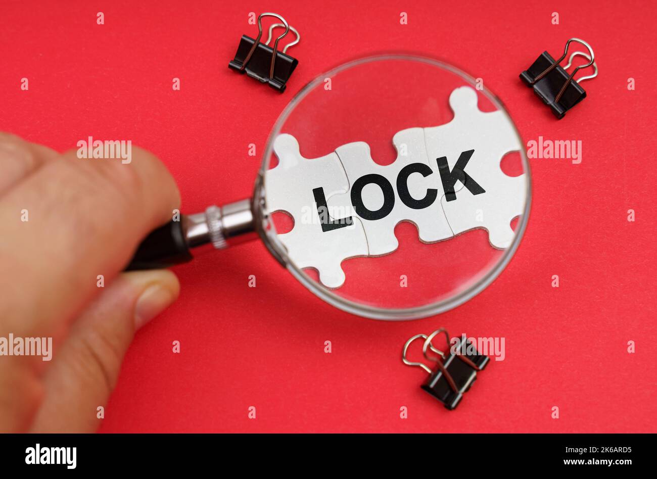 Business concept. A man looks through a magnifying glass at puzzles ...