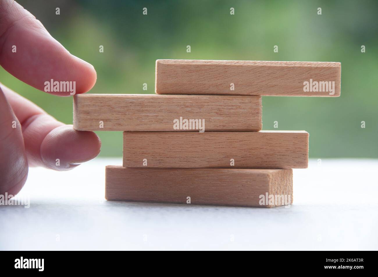 Hand pulling one wooden block with customizable space for text or ideas ...