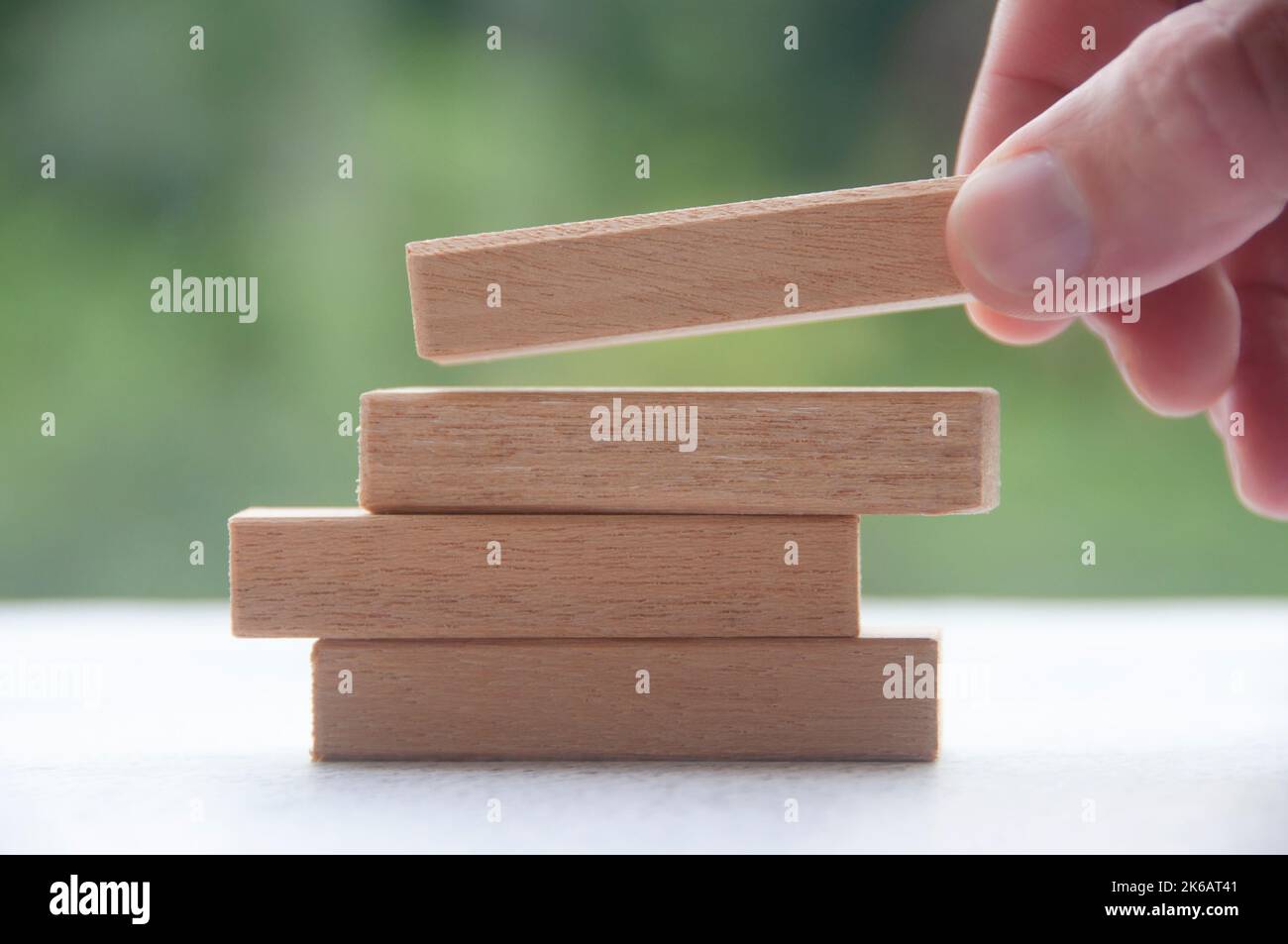 Hand placing one wooden blocks with customizable space for text or ...