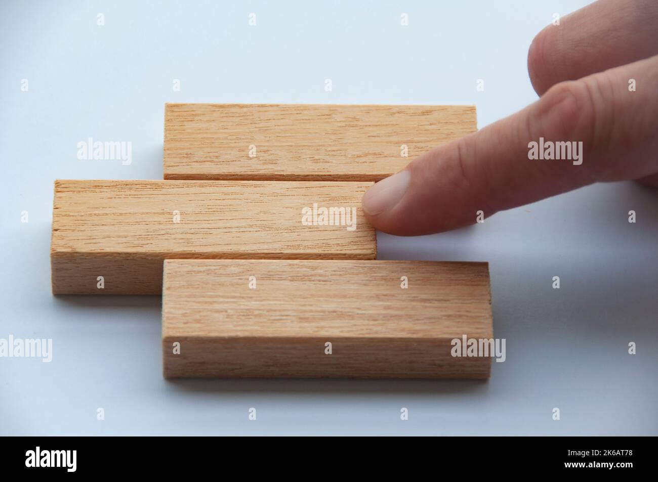 Finger pushing one wooden block with customizable space for text or ...