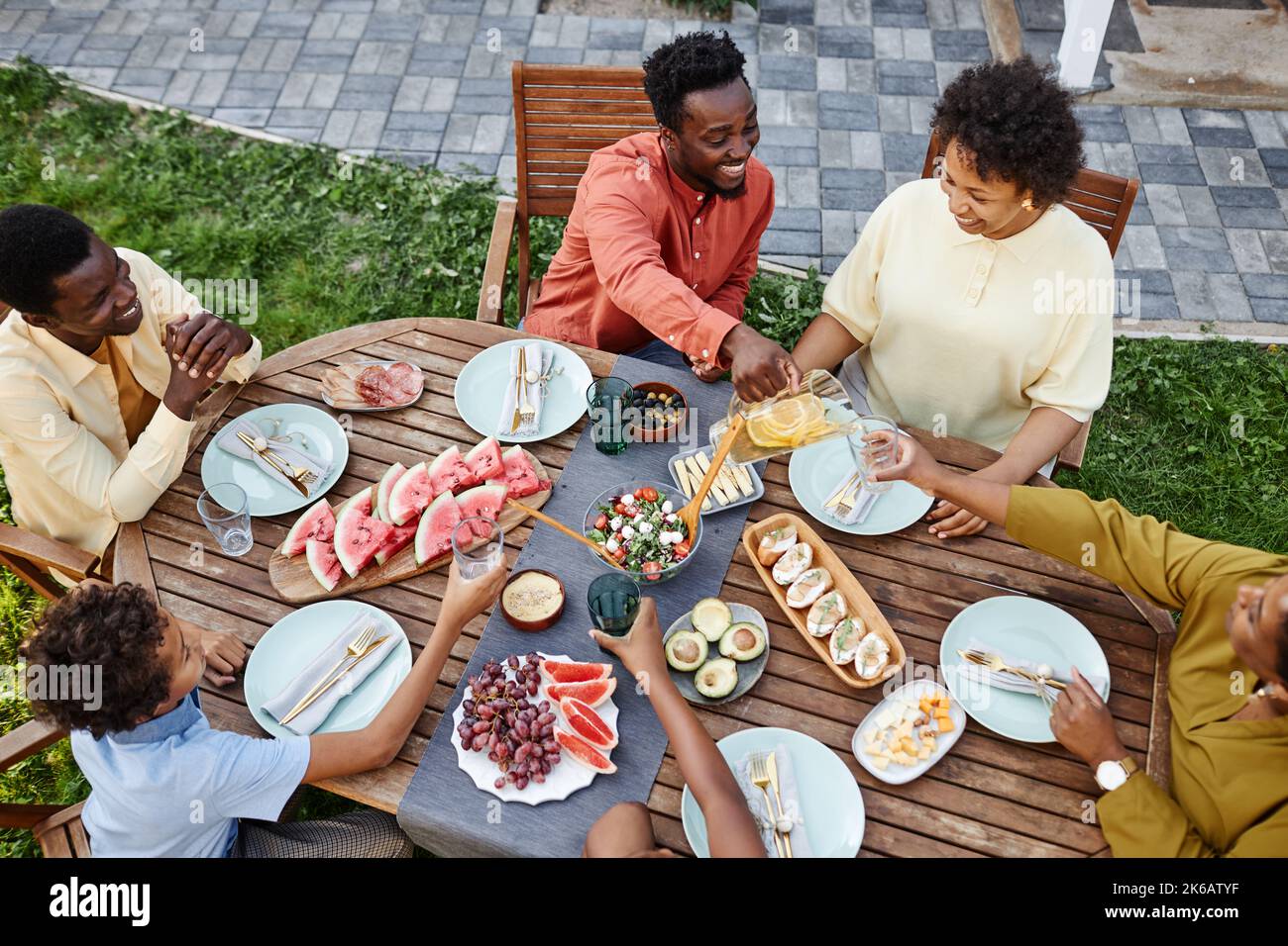 Top view at happy black family enjoying dinner outdoors during Summer ...