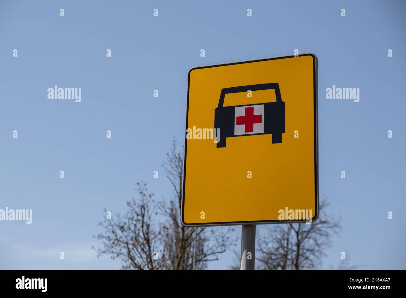 Road sign that shows way for ambulance. Ambulance yellow street sign on ...