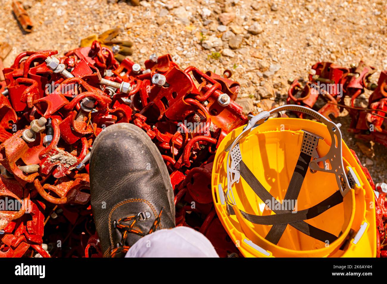 View from above on worker who wears safety shoe and tramples on pile ...