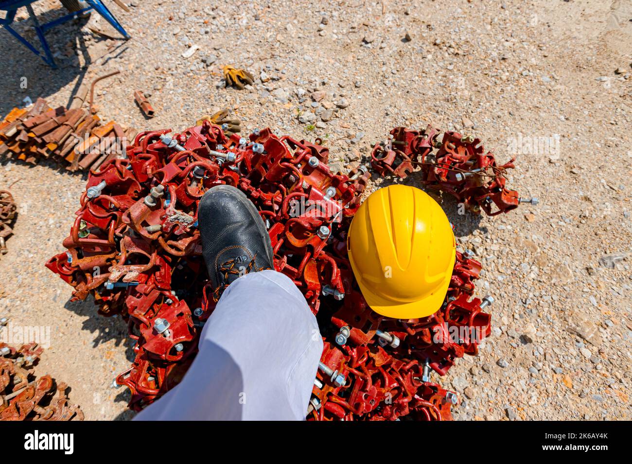 View from above on worker who wears safety shoe and tramples on pile ...