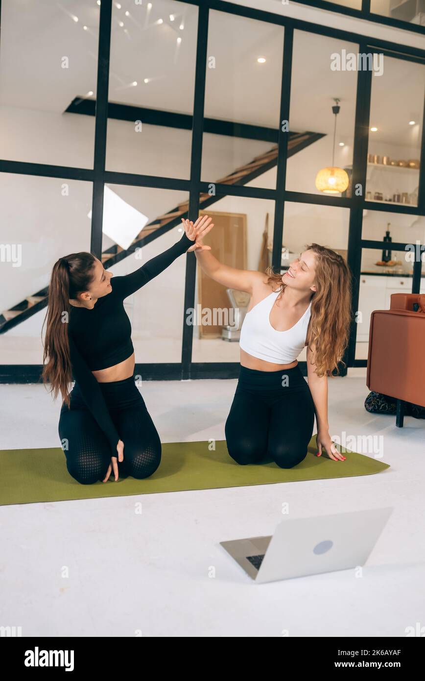 Two women while sitting in the lotus position give a high five Stock ...