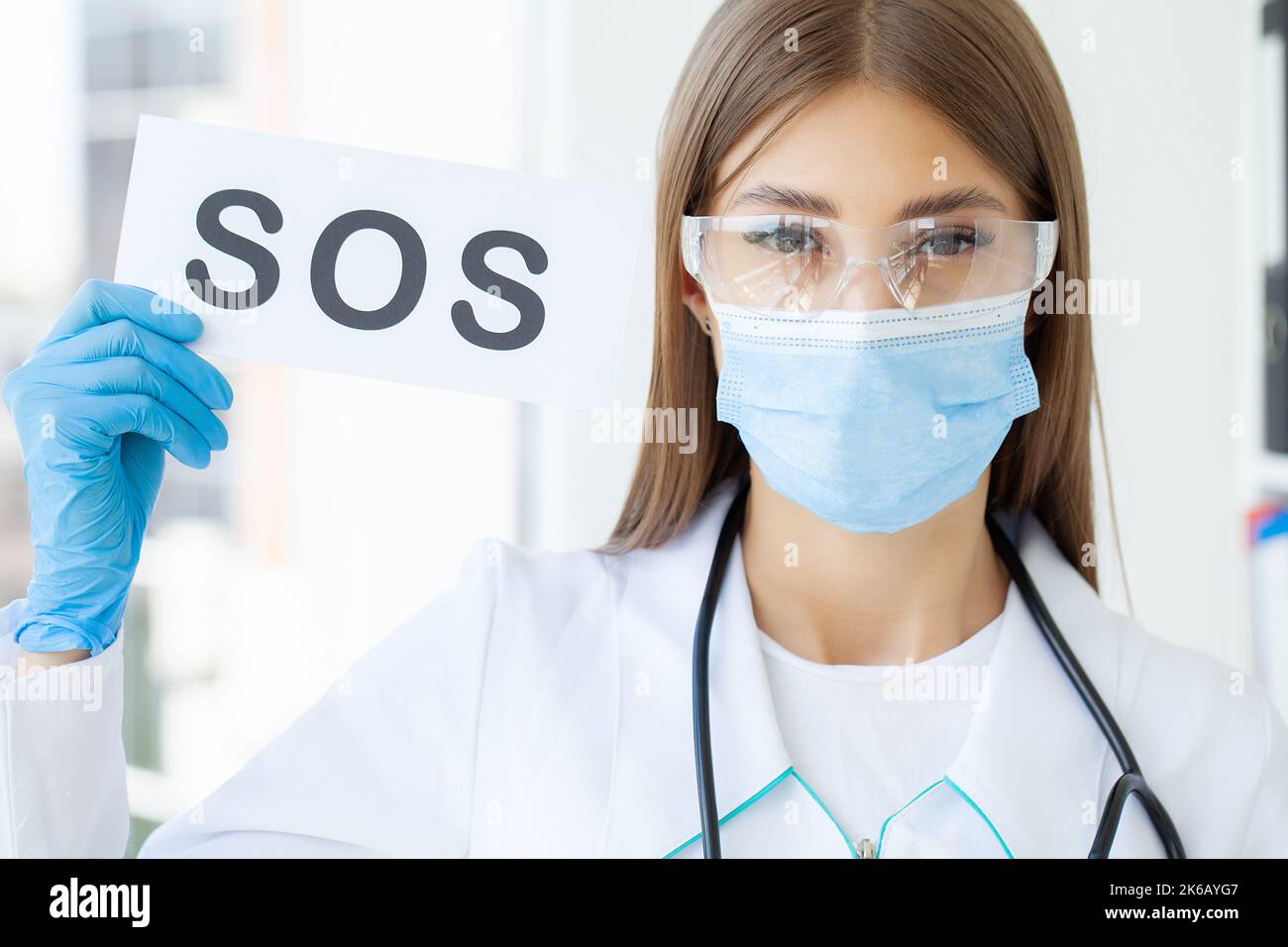 The doctor is holding a card with the Sos symbol in the office of the ...