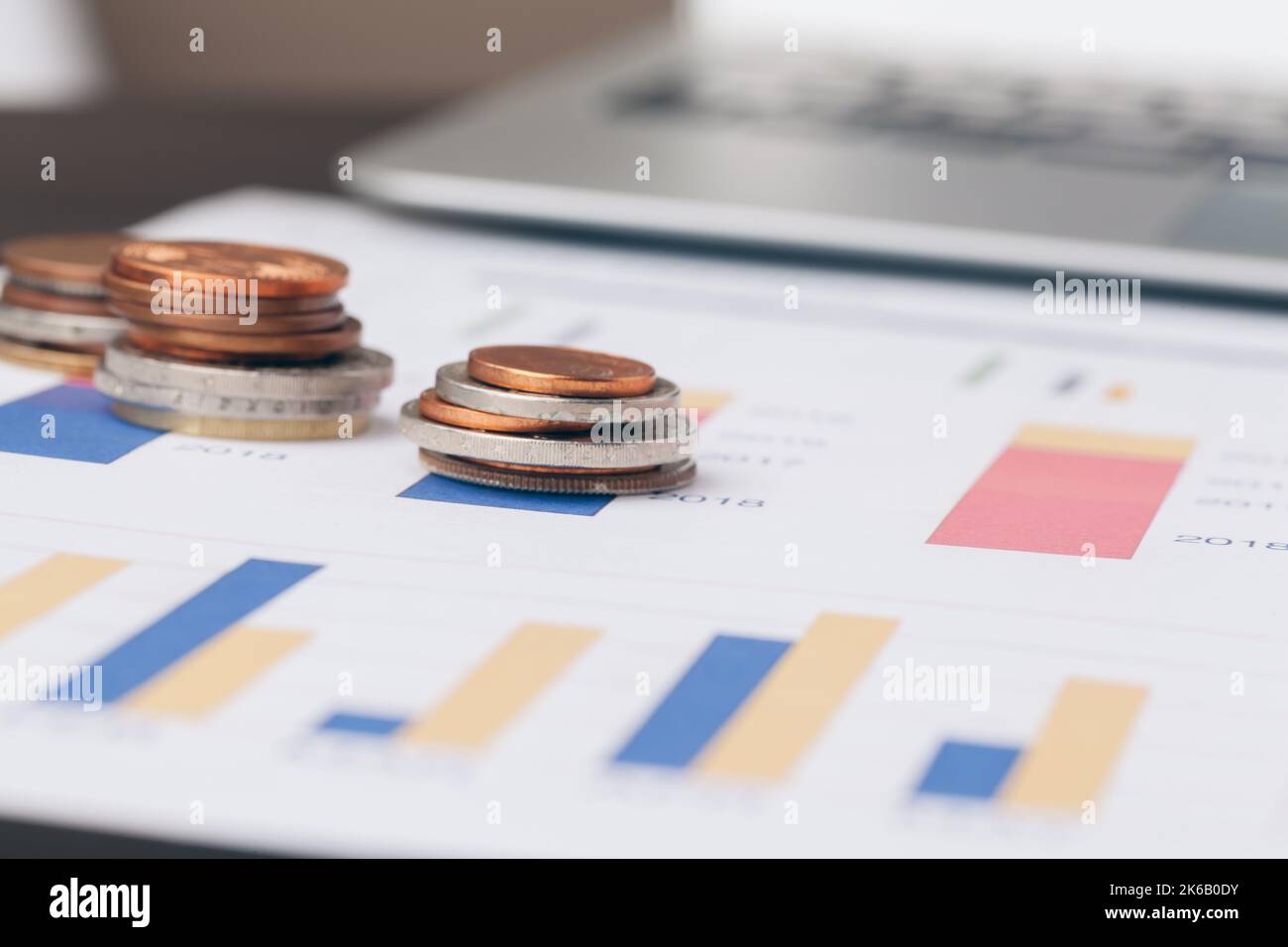 pile of money coins with graph paper on wood table, concept in account ...