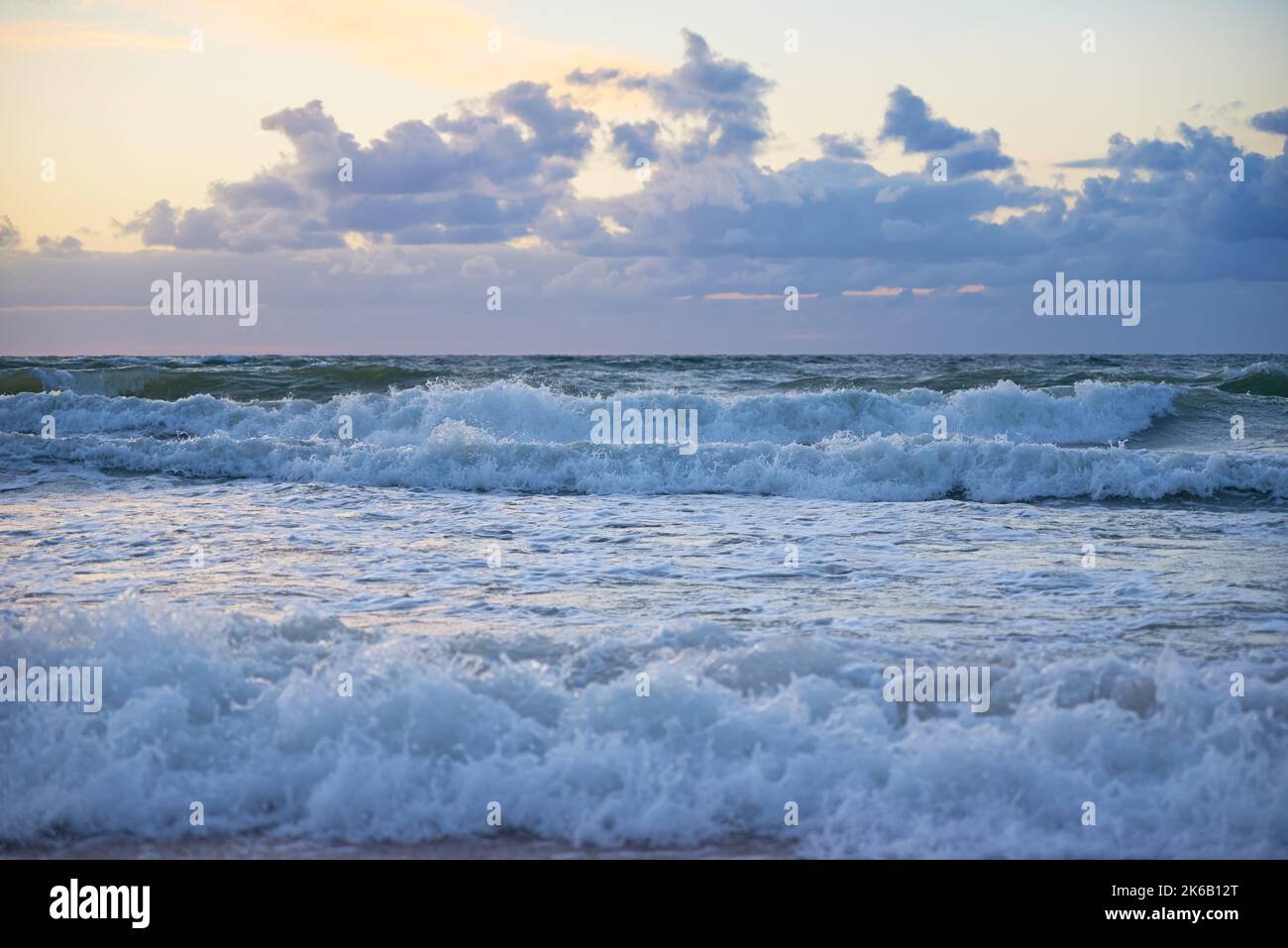 Panoramic view of sea beach with splashing waves against dramatic ...