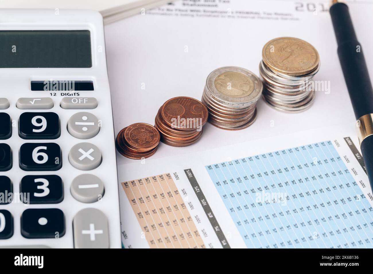 pile of money coins with graph paper on wood table, concept in account ...