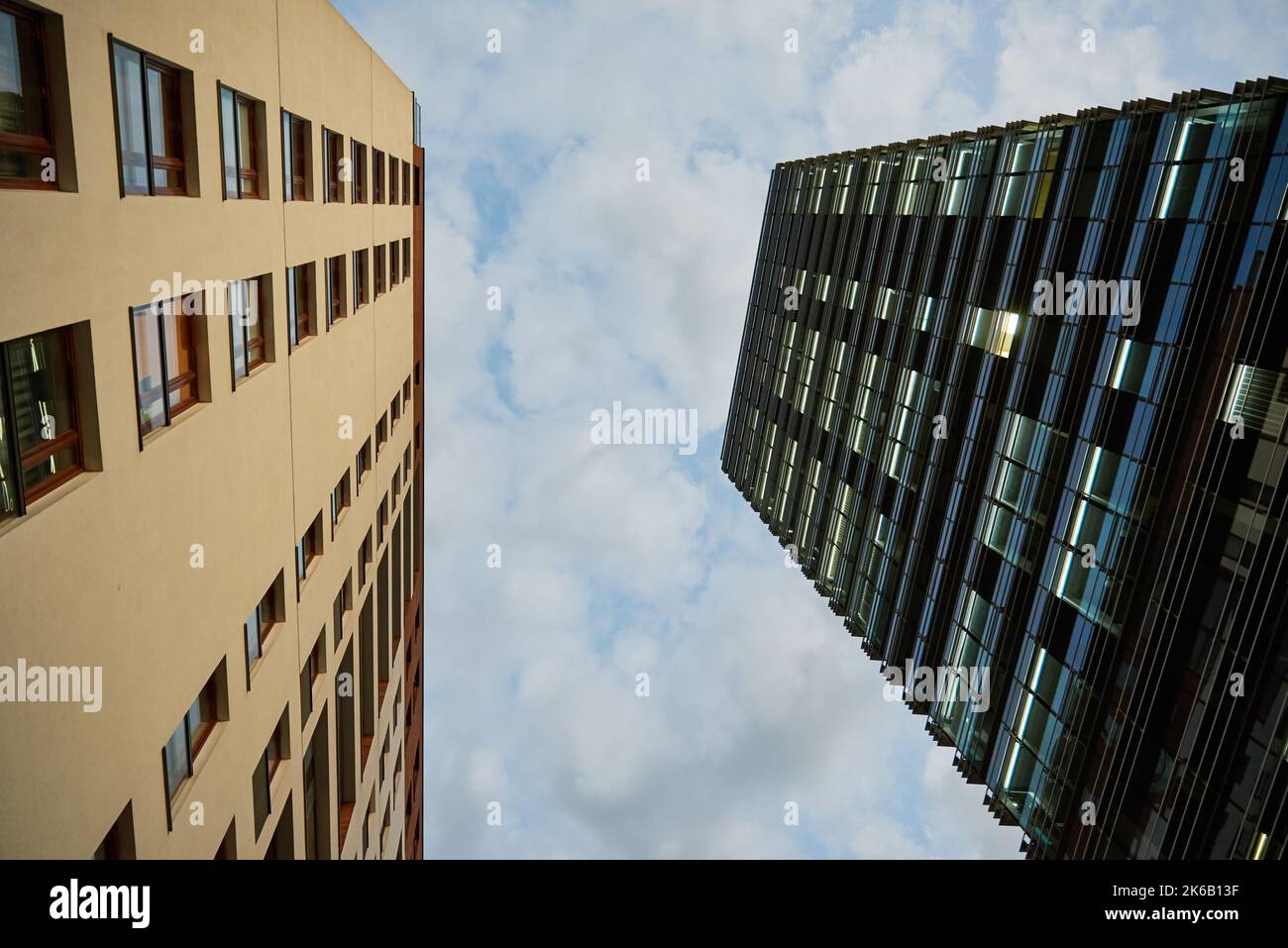 Facade of new and old buildings opposite each other against cloudy sky ...