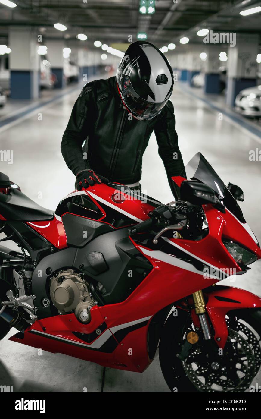 Portrait of a motorcycle rider with a helmet and race motorcycle in a ...