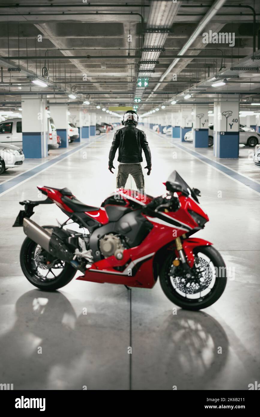 Back view of a motorcycle rider with a helmet and defocused race ...