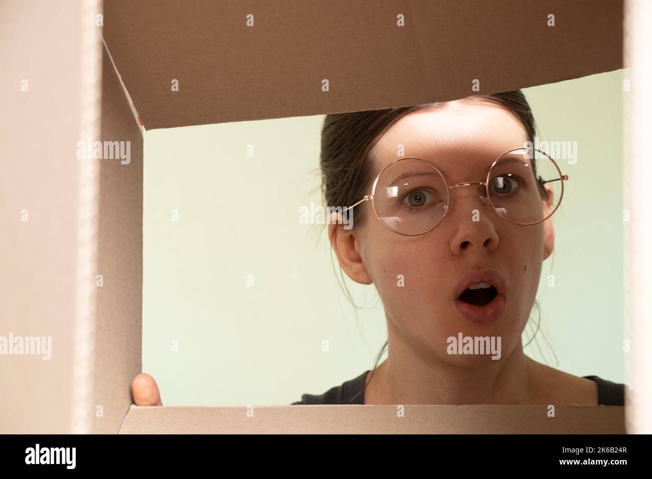 the girl's face looks into the cardboard box, receiving the parcel ...