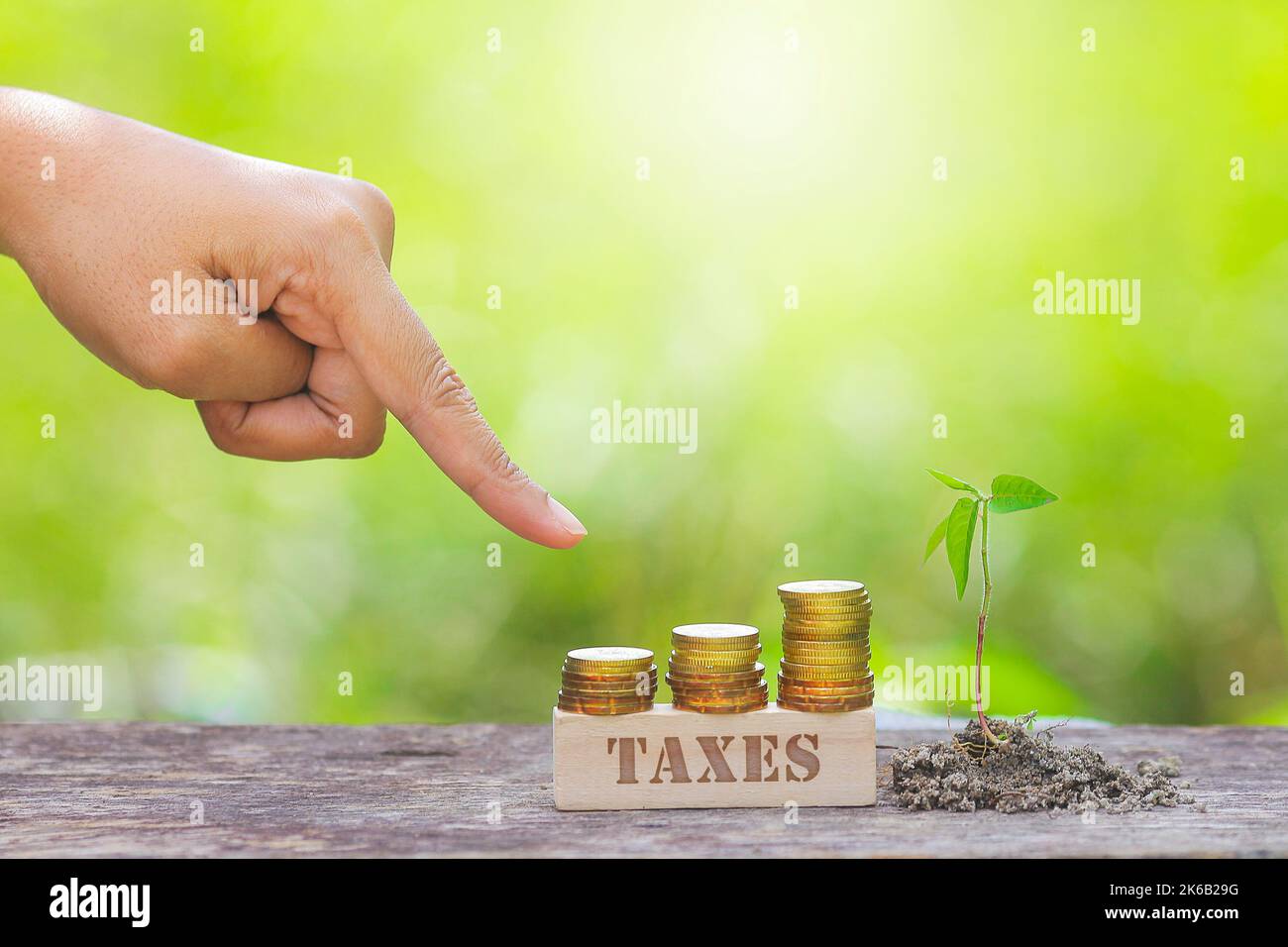TAXES WORD WITH BUSINESSMAN HAND POINTING TO STACK OF GOLD COIN Stock ...