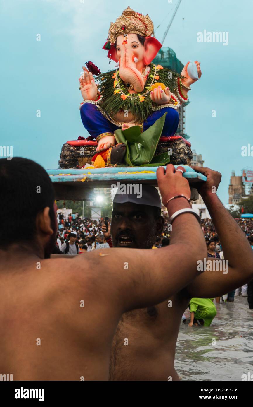 A vertical shot of men carrying the Ganesha statue during Ganpati ...